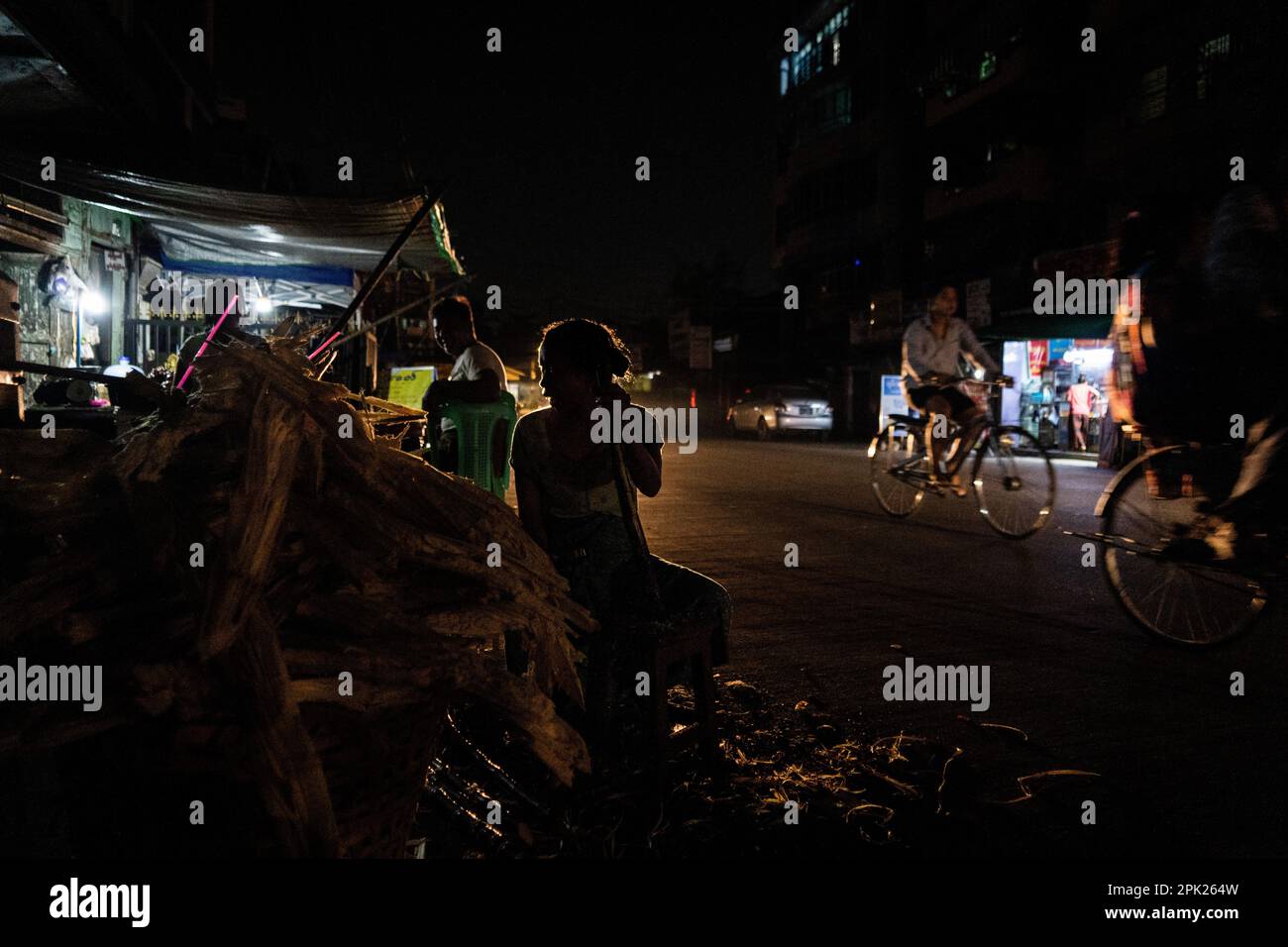 April 2, 2023, Yangon, Myanmar: A sugarcane juice maker chops by the ...