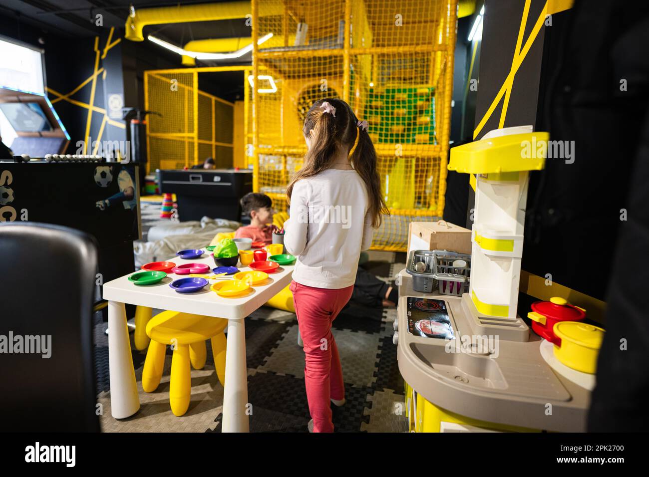 Preschooler girl playing in kids kitchen at children play center Stock ...