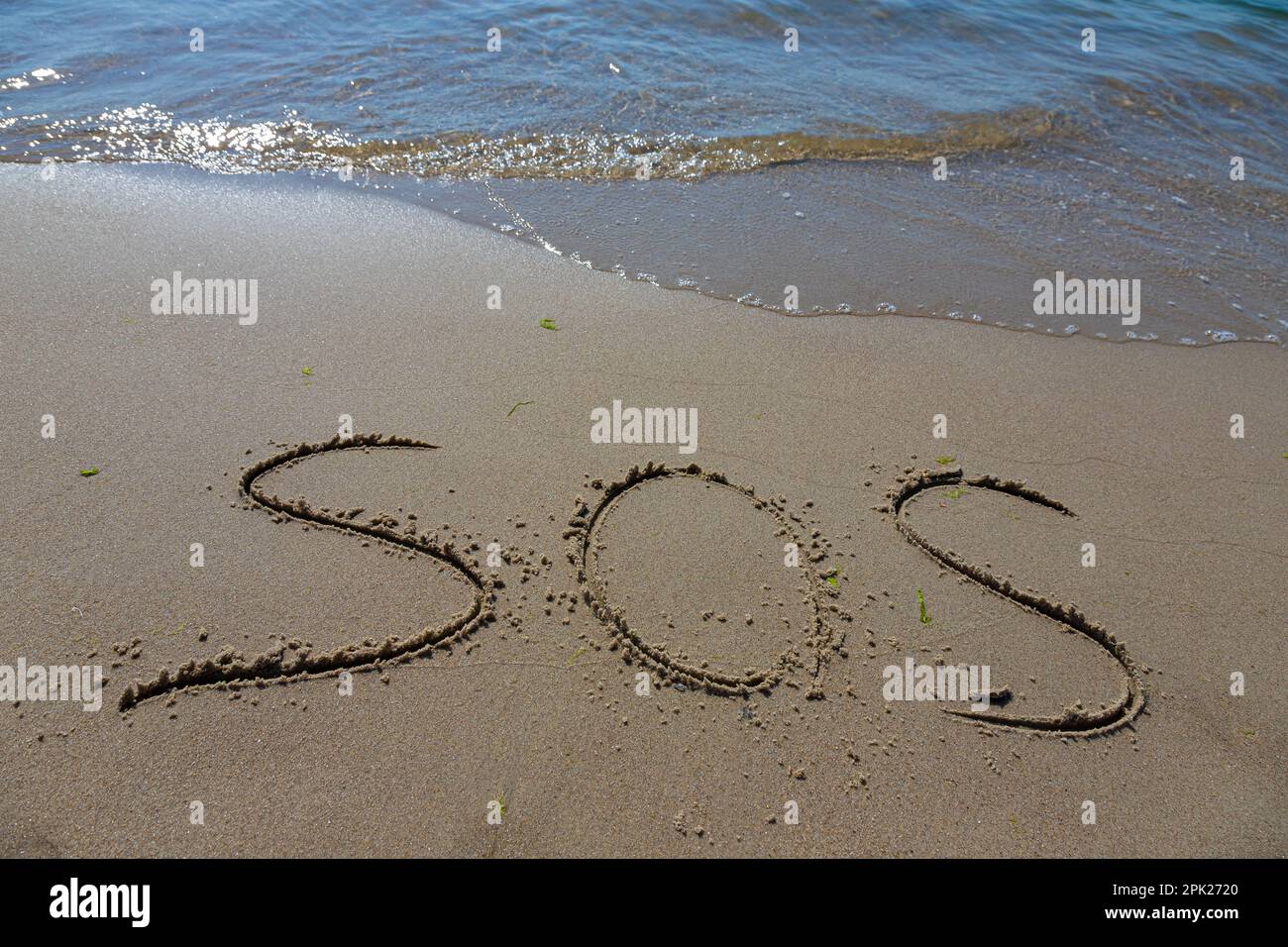The inscription on the sand at the beach sos Stock Photo - Alamy