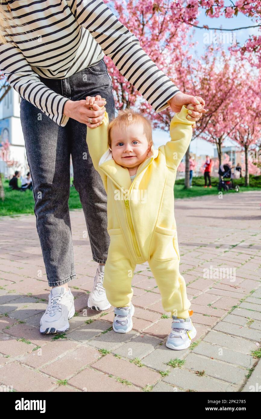 Spring park stroll with mom and son practicing walking Stock Photo - Alamy
