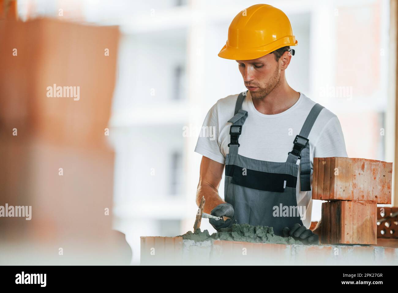 Building process. Young man working in uniform at construction at ...