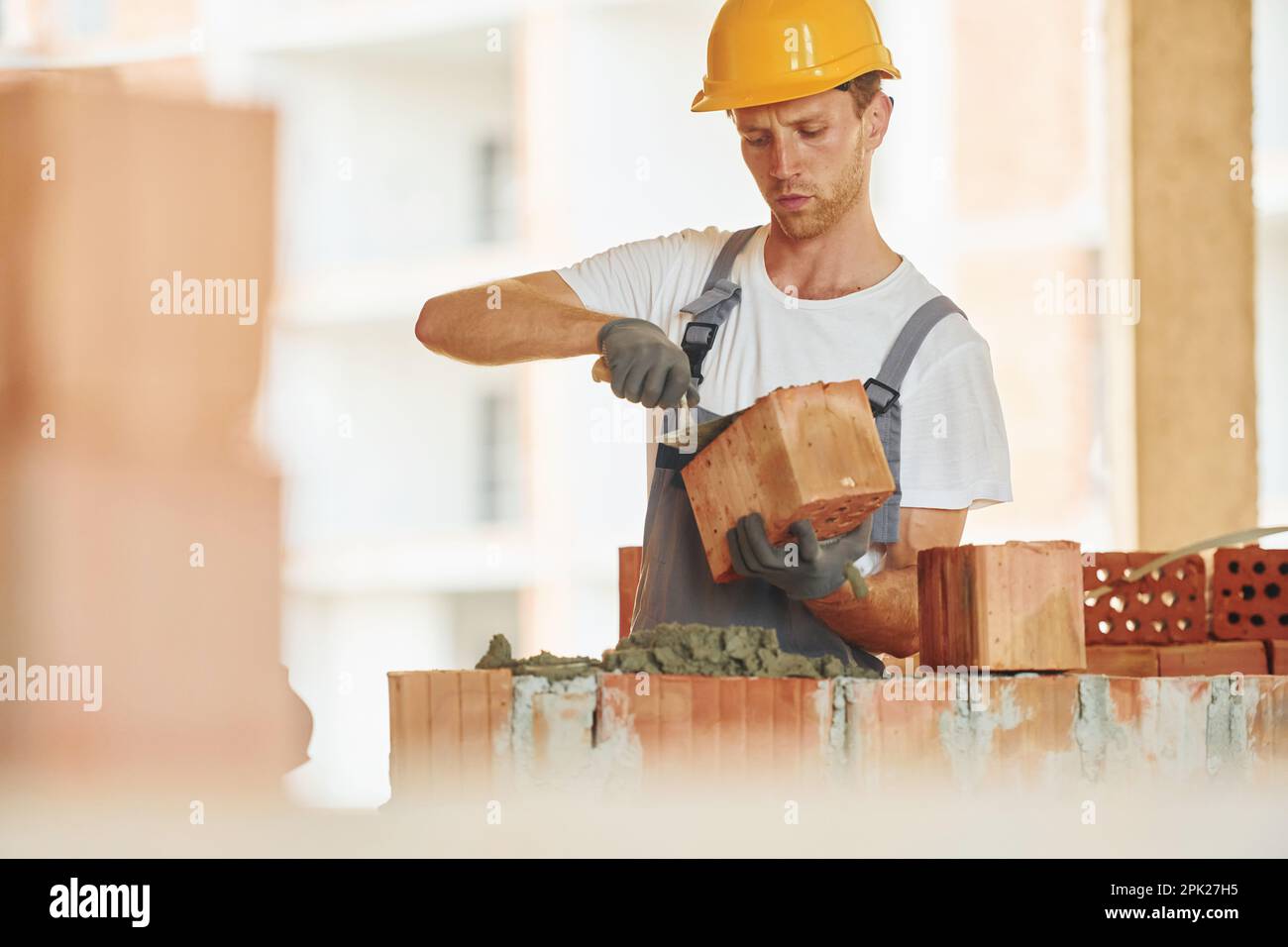 Building process. Young man working in uniform at construction at ...