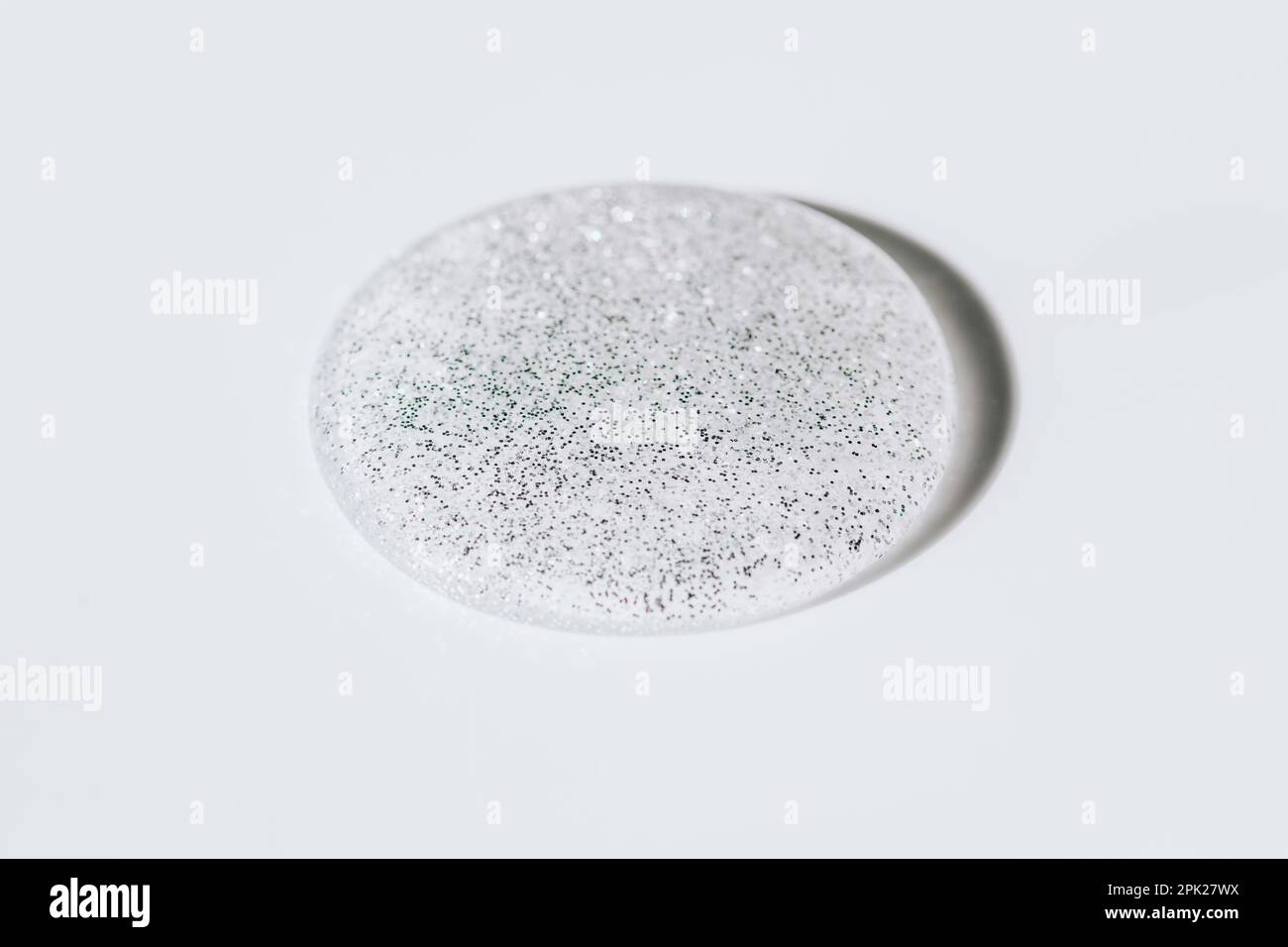 The texture of a liquid gel cosmetic product with silver particles on a ...