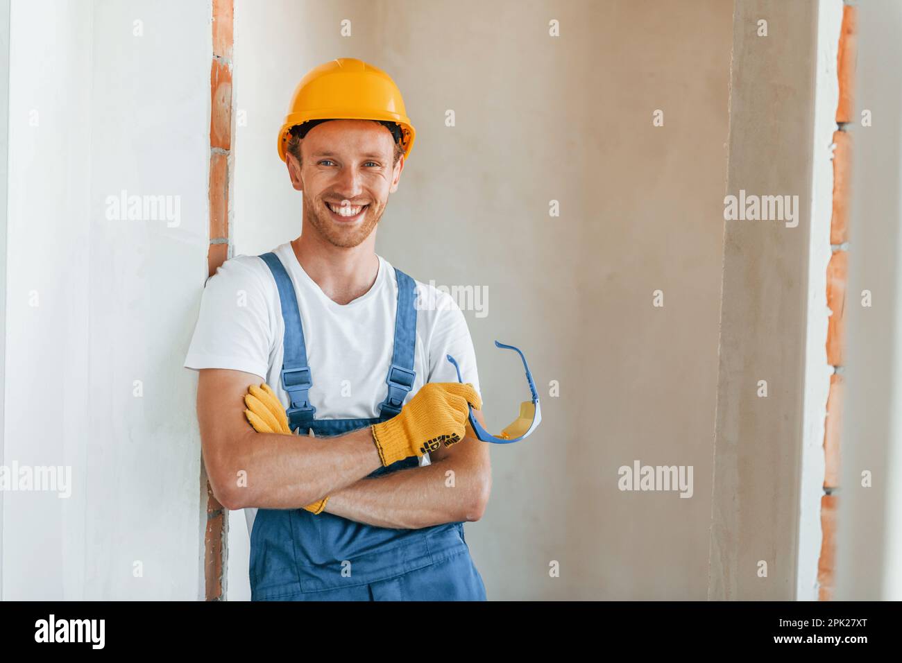 Professional service. Young man working in uniform at construction at ...