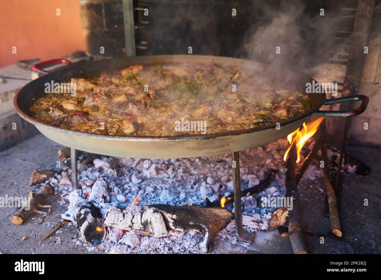 a traditional spanish paella being cooked on fire Stock Photo - Alamy