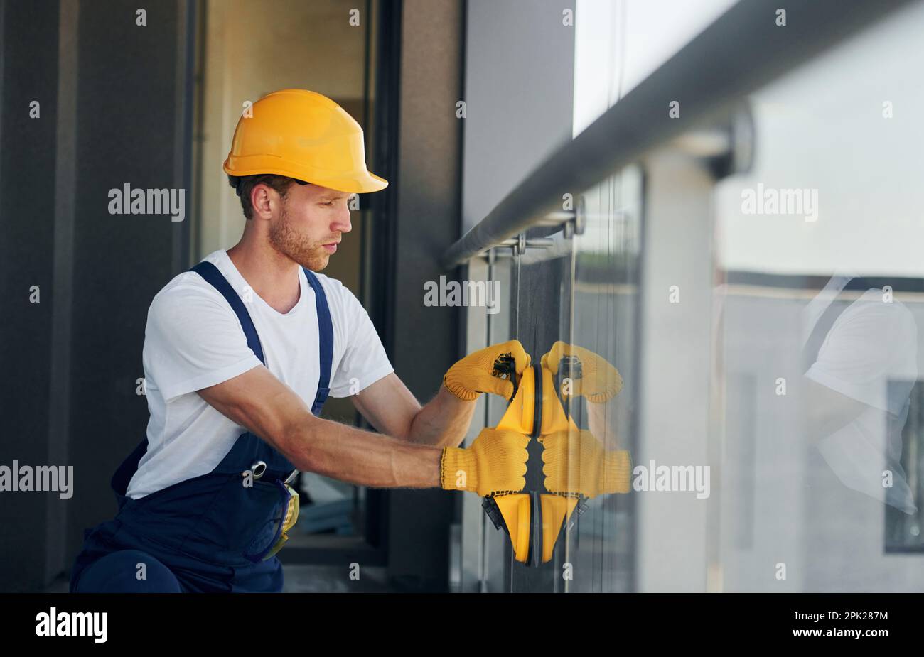 Installation of windows. Young man working in uniform at construction ...