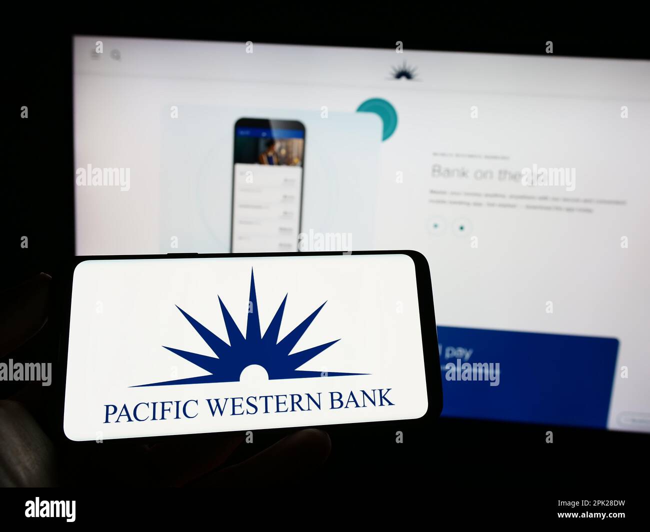 Person holding cellphone with logo of US banking company PacWest ...