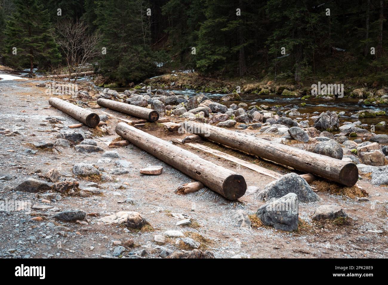 Benches made of natural tree trunks in a mountain valley by a stream ...