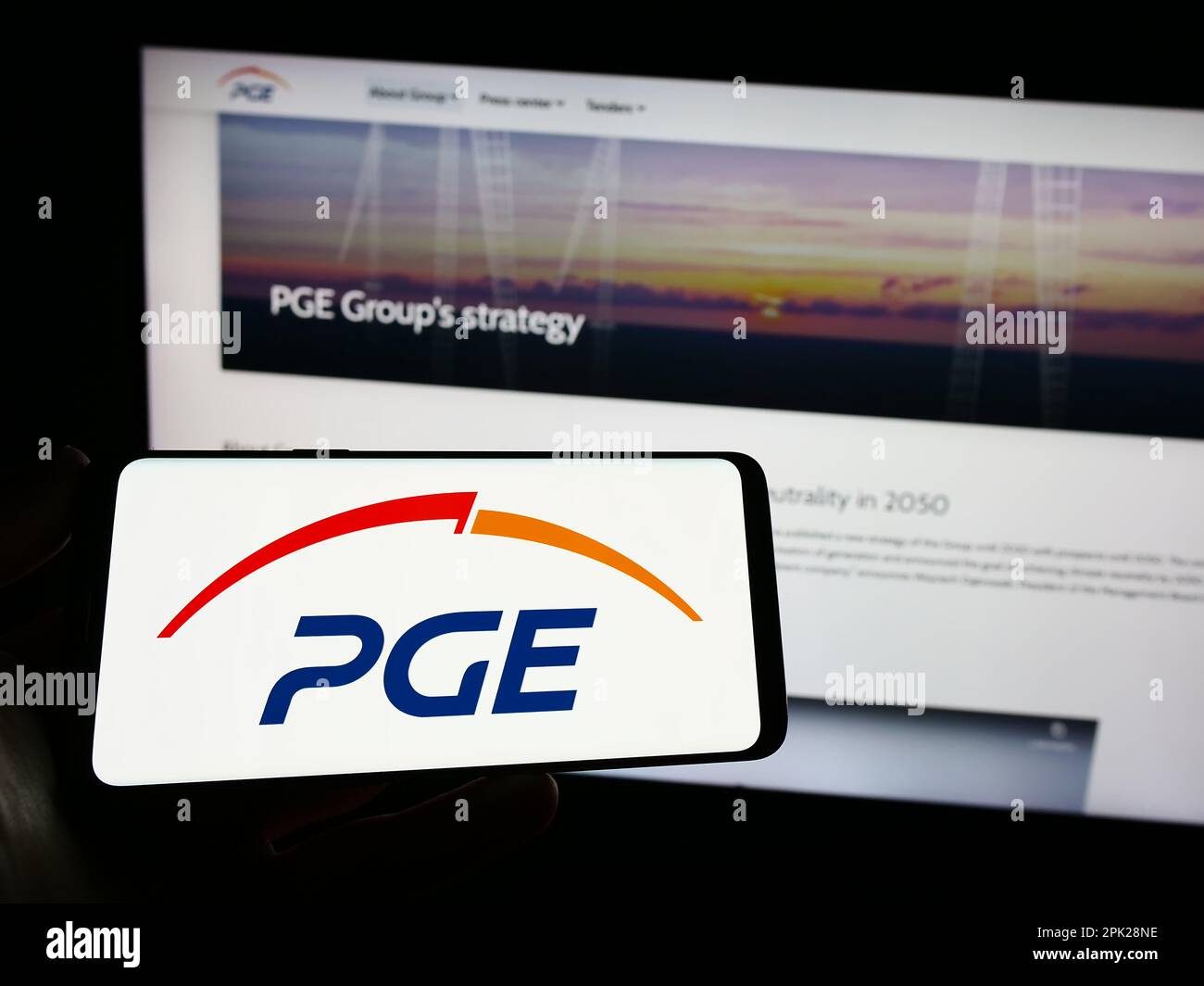 Person holding smartphone with logo of company PGE Polska Grupa ...