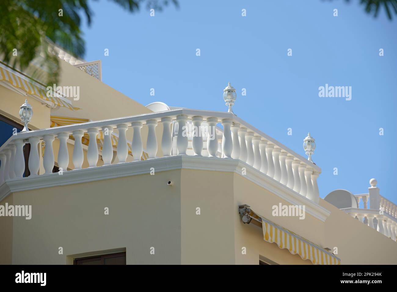 Closeup white concrete balustrade above plastered and painted yellow ...