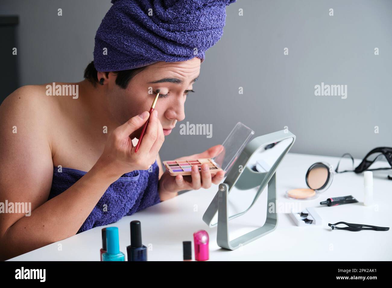 Young transgender man applying eyeshadow Stock Photo - Alamy