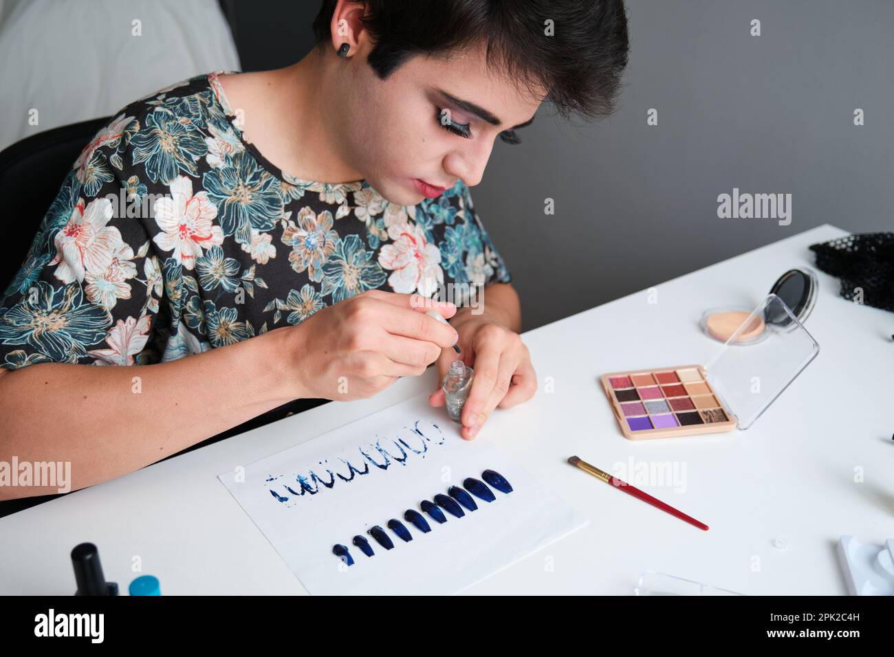 Young transgender man painting false nails Stock Photo - Alamy