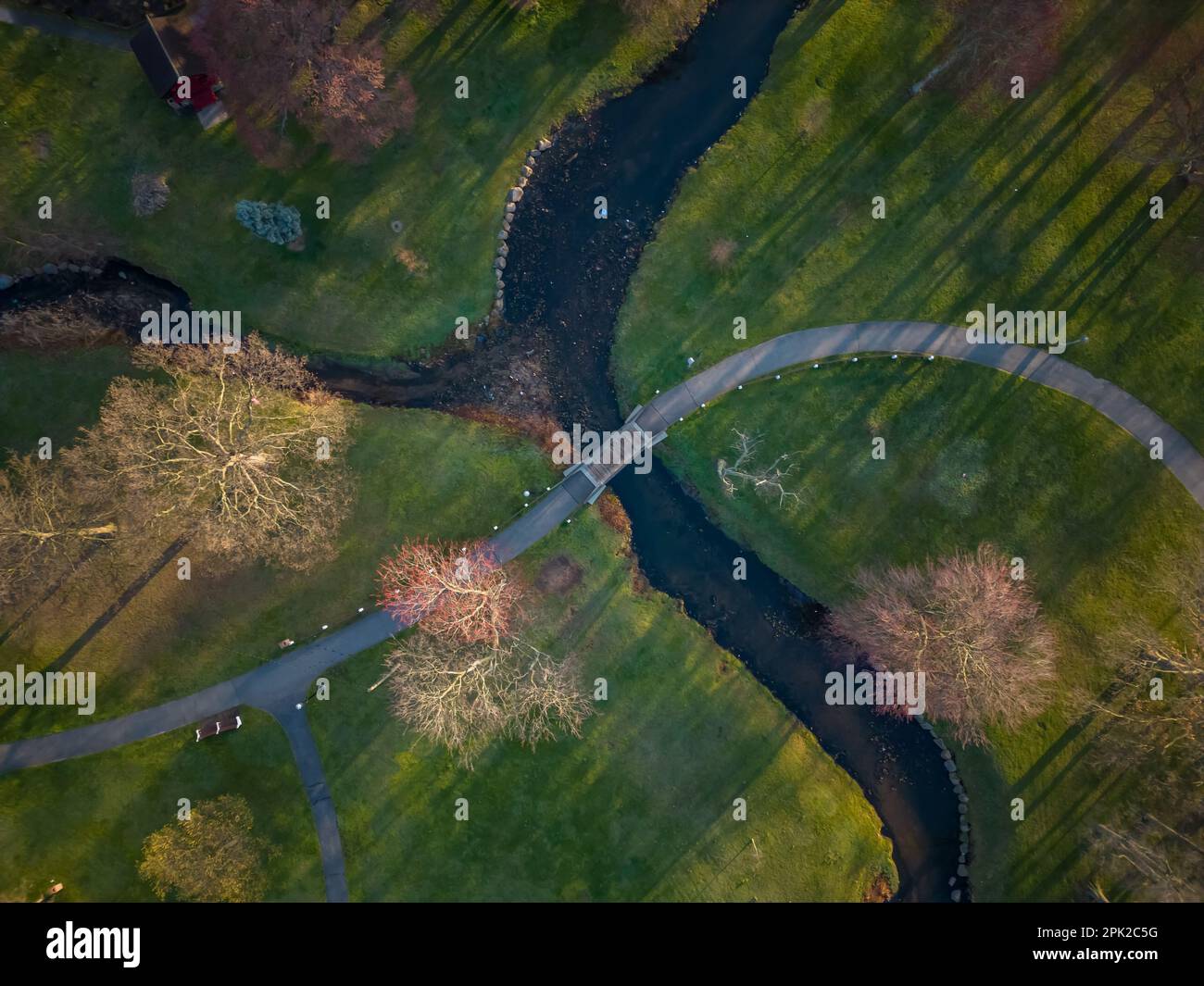 An aerial shot of a pathway with a surrounding landscape of green grass ...