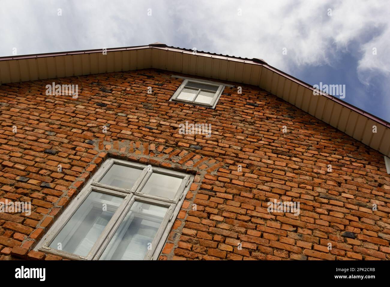 Red brick wall with windows. Bottom view on the background of the sky ...