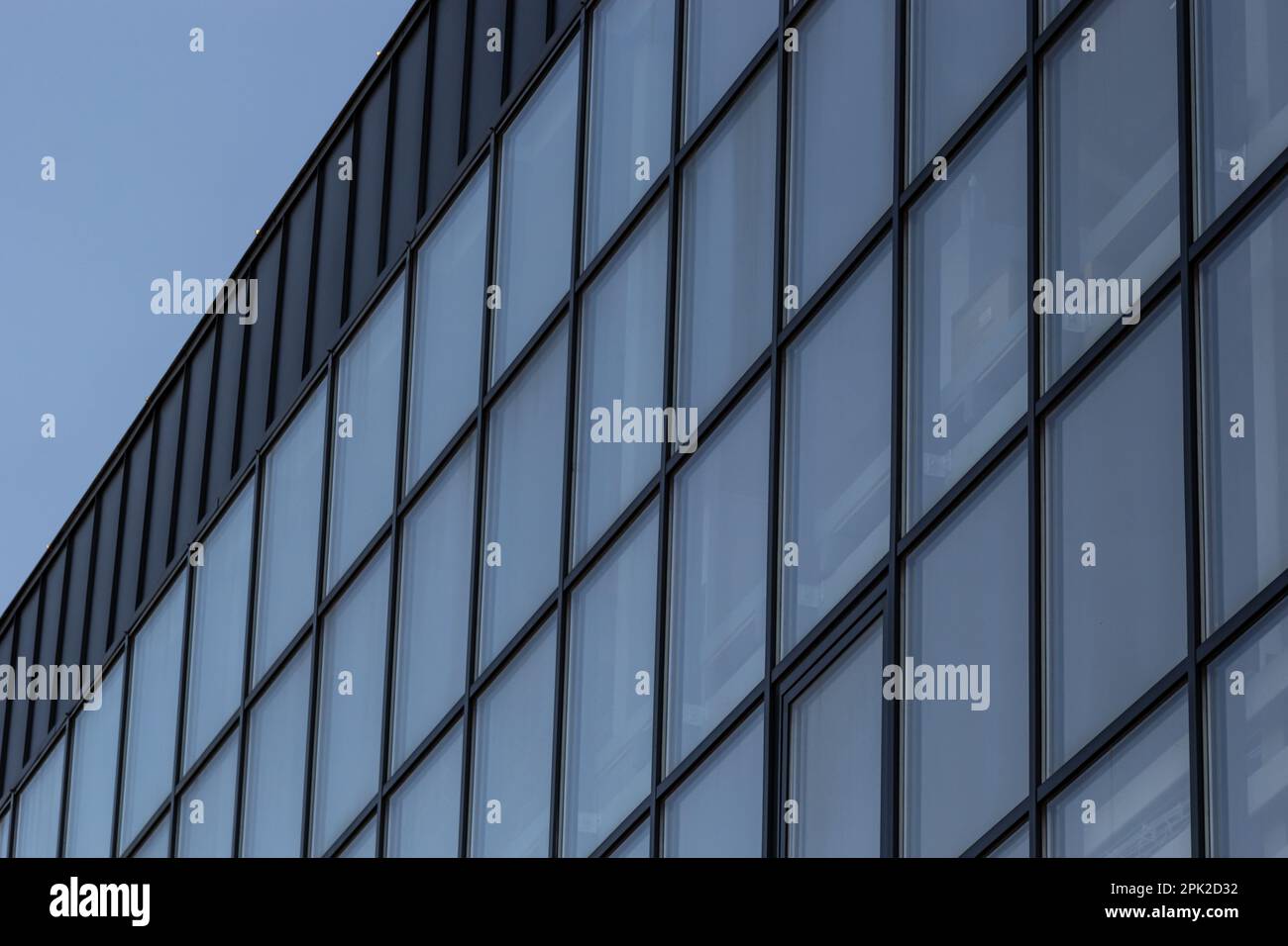 Bottom view of a modern skyscraper building with glass window against ...