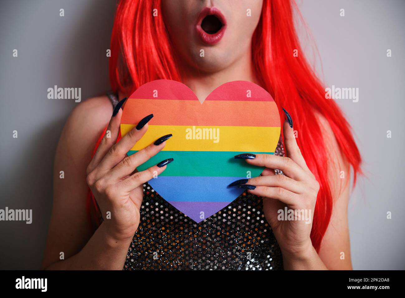 Unrecognizable transgender person surprised holding a rainbow flag ...