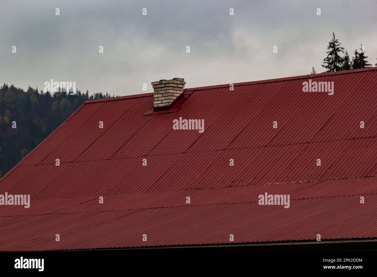 Red house roof with red brick chimney. Ceramic chimney, metal roof ...