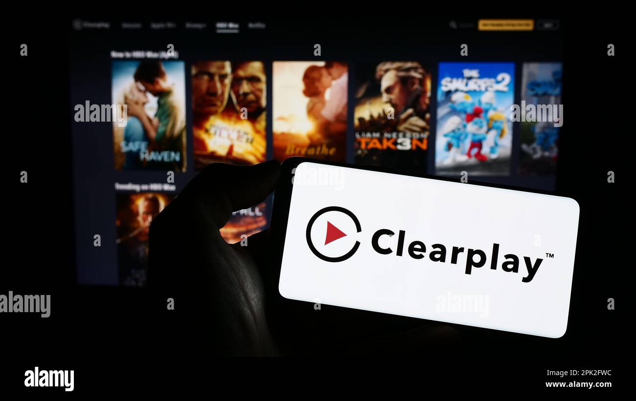 Person holding cellphone with logo of parental control company Clearplay Inc. on screen in front ...