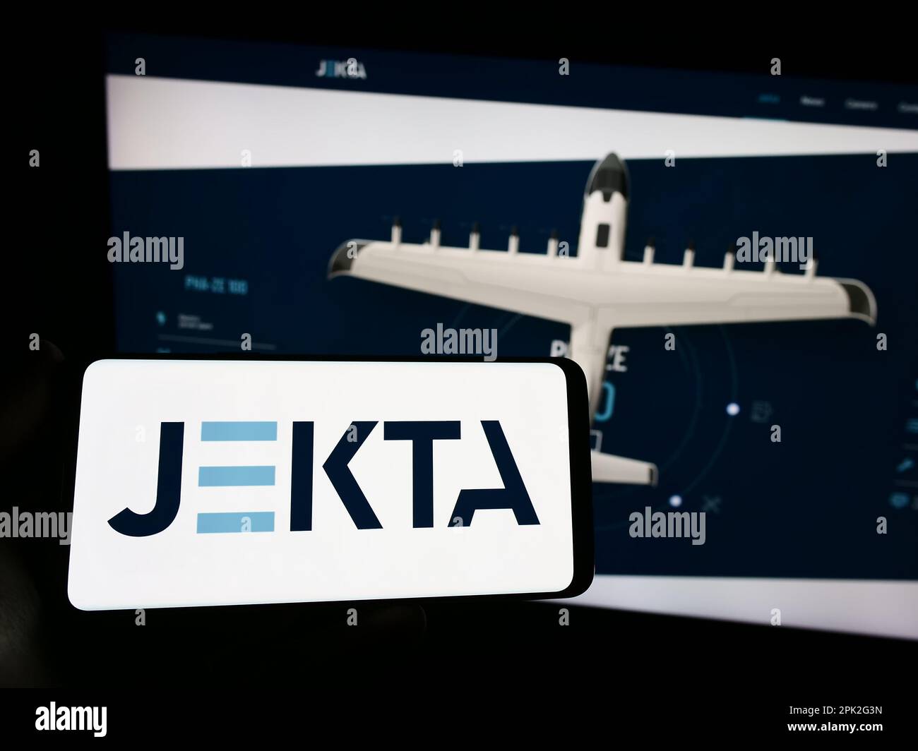 Person holding smartphone with logo of aviation company Jekta ...