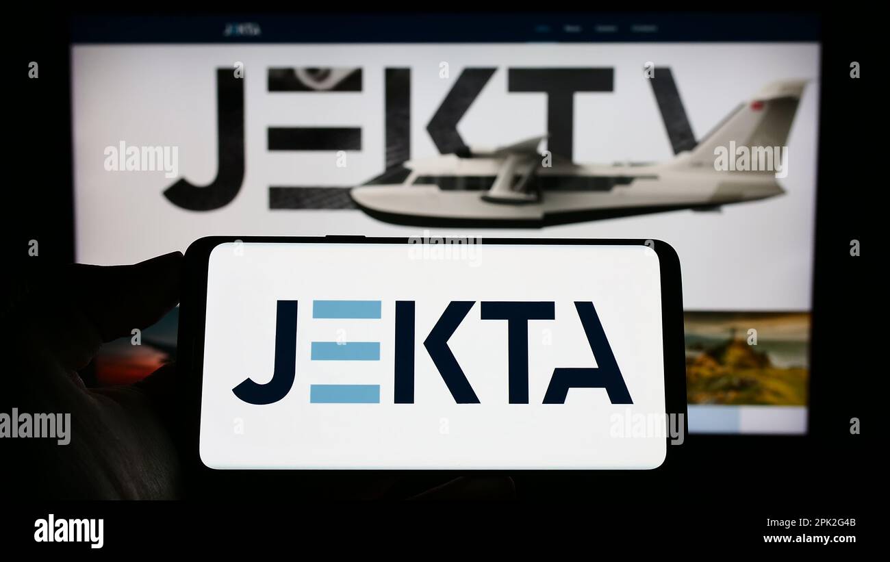 Person holding mobile phone with logo of aviation company Jekta ...