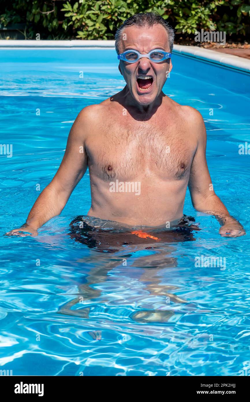A middle-aged white man cheers while partially submerged in a swimming ...