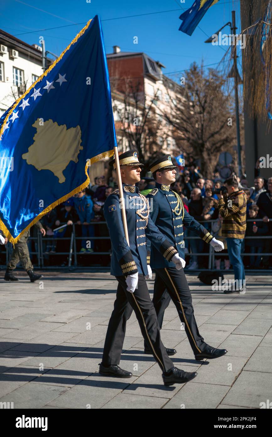 A military parade is marching through a public town square, proudly ...