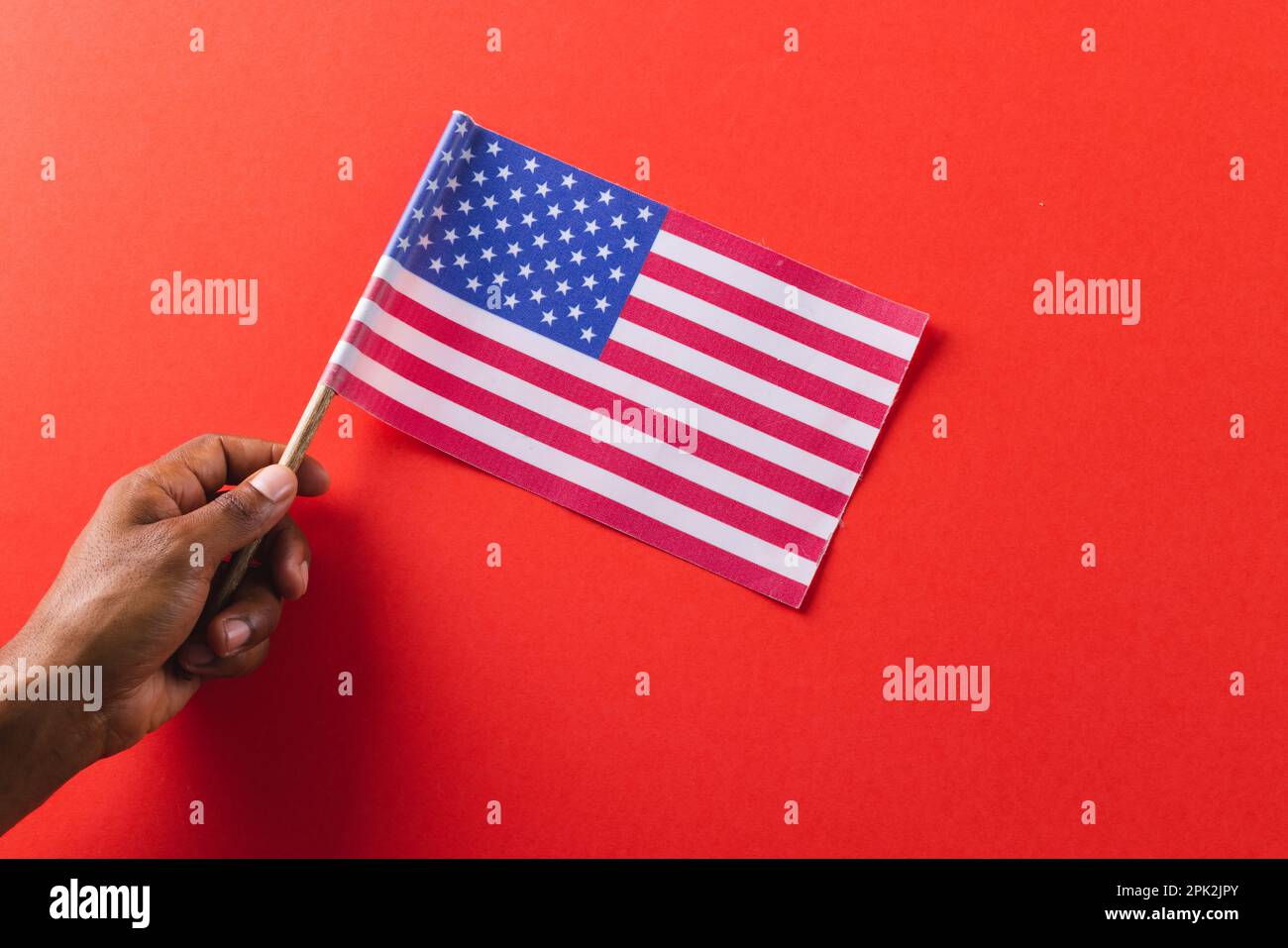 Hand of biracial man holding flag of united states of america with copy ...