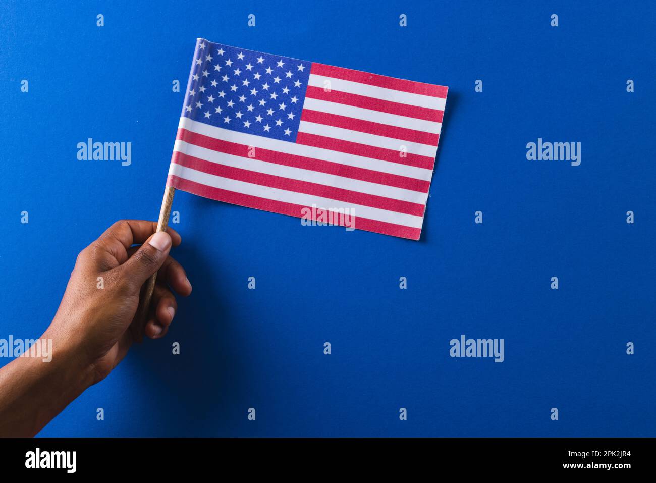 Hand of biracial man holding flag of united states of america with copy ...