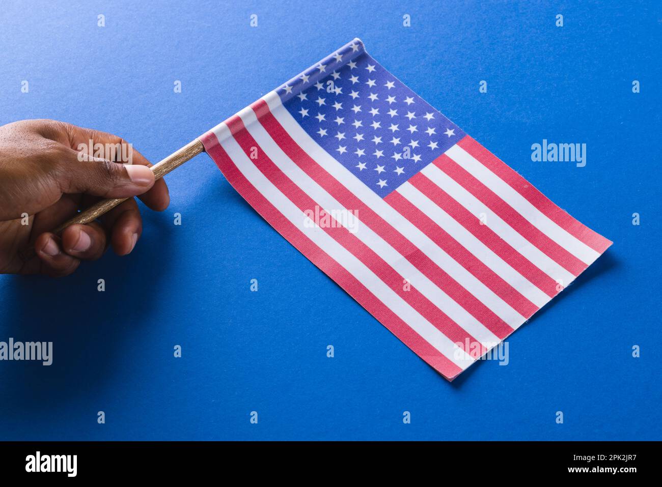 Hand of biracial man holding flag of united states of america with copy ...