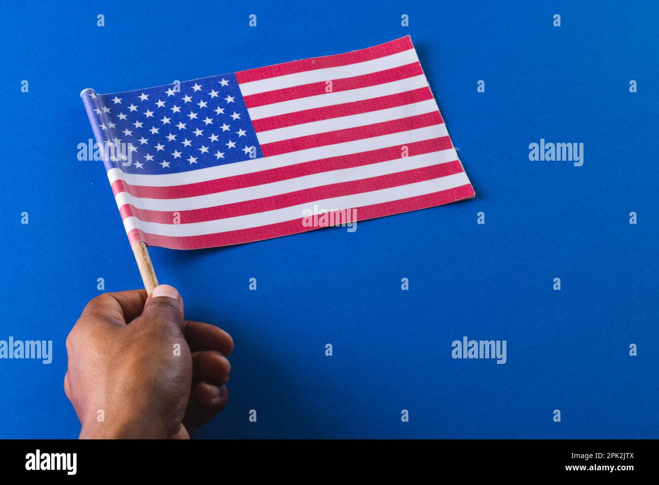 Hand of biracial man holding flag of united states of america with copy ...