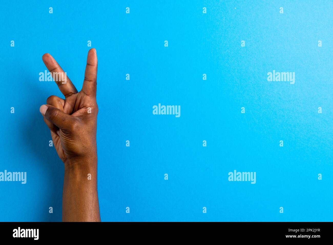 Close up of hand of biracial man showing peace sign with copy space on ...