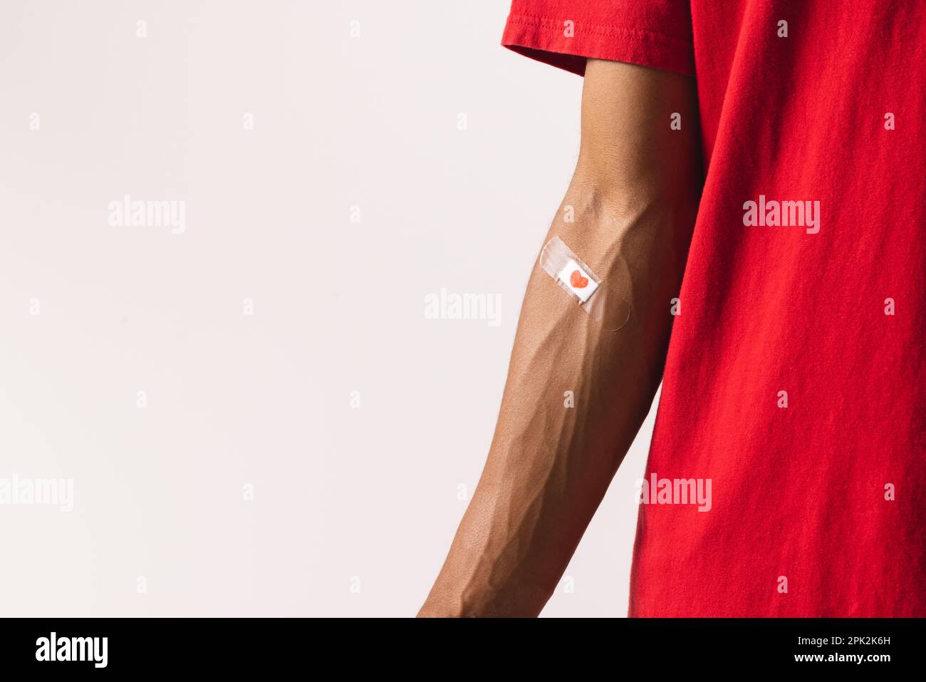 Midsection of biracial man with heart sticking plaster on arm, on white ...