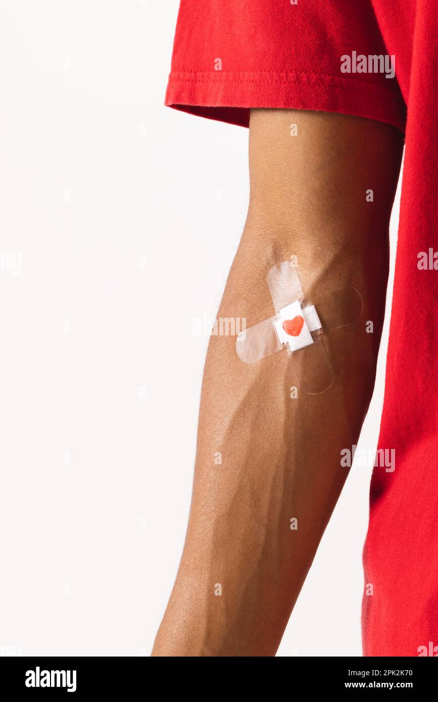 Midsection of biracial man with heart sticking plaster on arm, on white ...