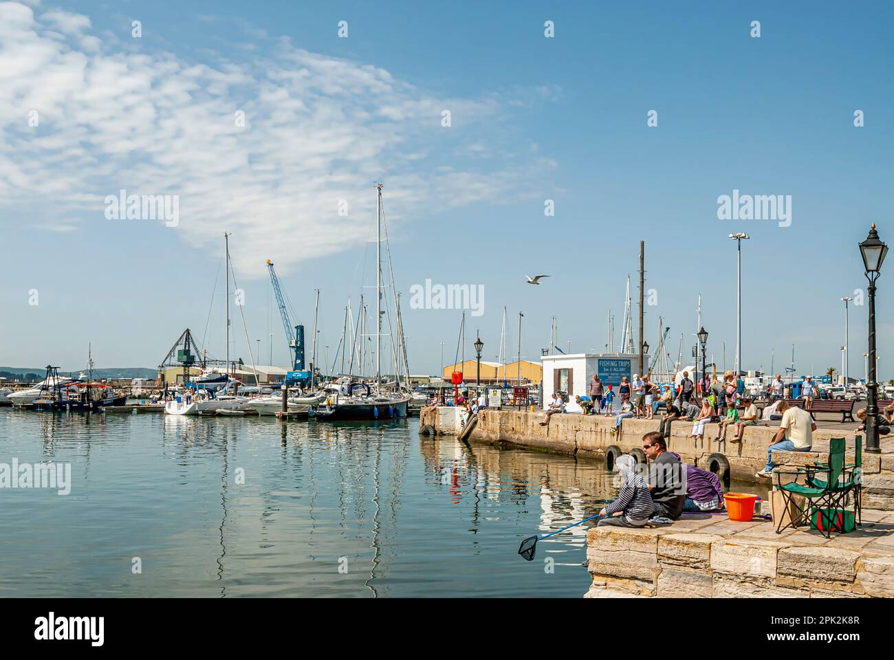 Angler at the waterfront of Poole harbour, Dorset, England, UK Stock ...