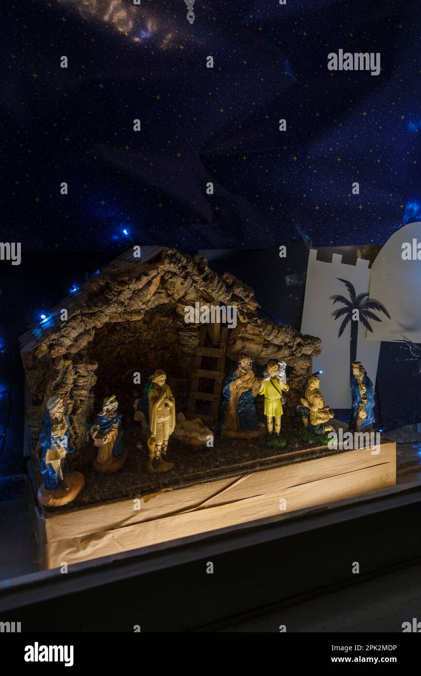 A model nativity crib with staue figures in a house window at Christmas ...