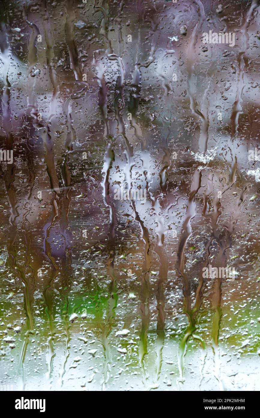 View through a rain soaked car window parked on the side of the road ...