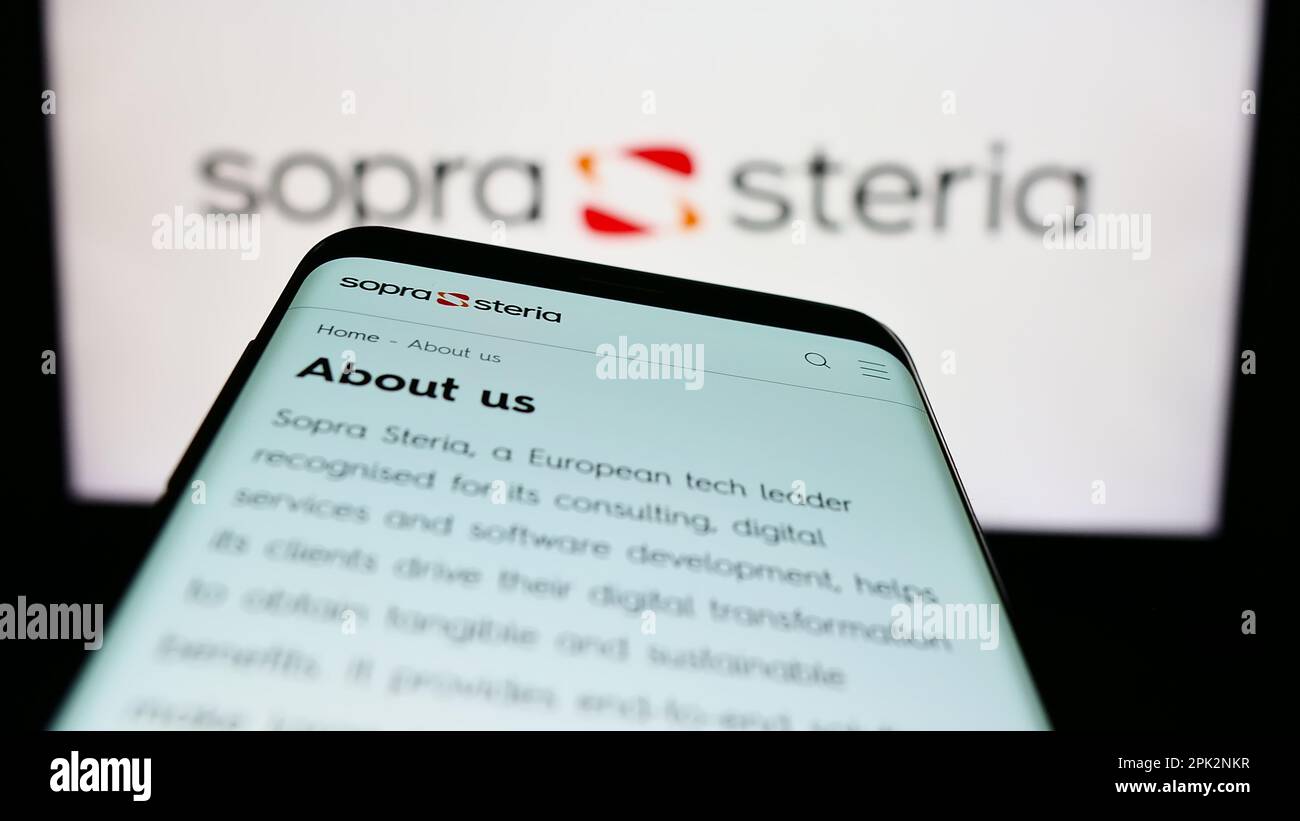 Smartphone with website of French company Sopra Steria Group SA on screen in front of business ...