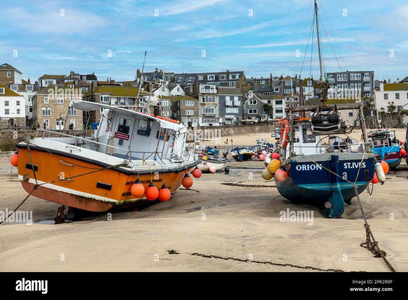 Moored, beached fishing boats on sandy beach in St. Ives harbour at low ...