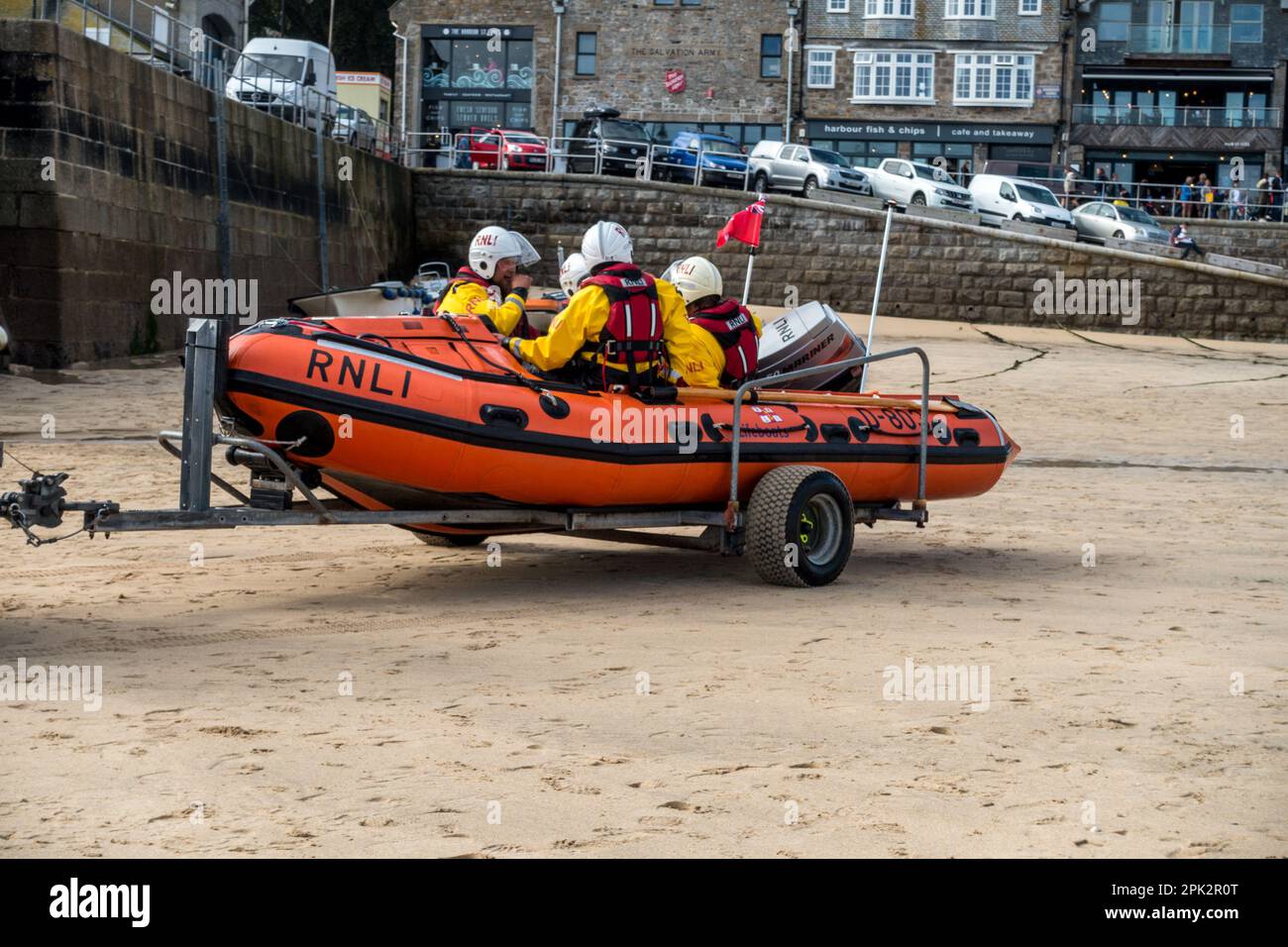 RNLI Lifeboat drill with lifeboat crew sitting in RIB on trailer St. Ives harbour, Cornwall ...
