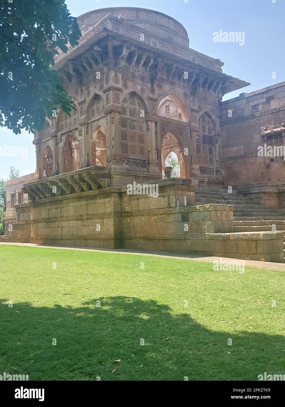 A grassy area outside a building is filled with bricks and stones ...