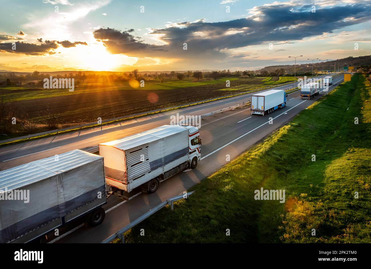Transportation trucks with trailers on an asphalt highway road in a ...