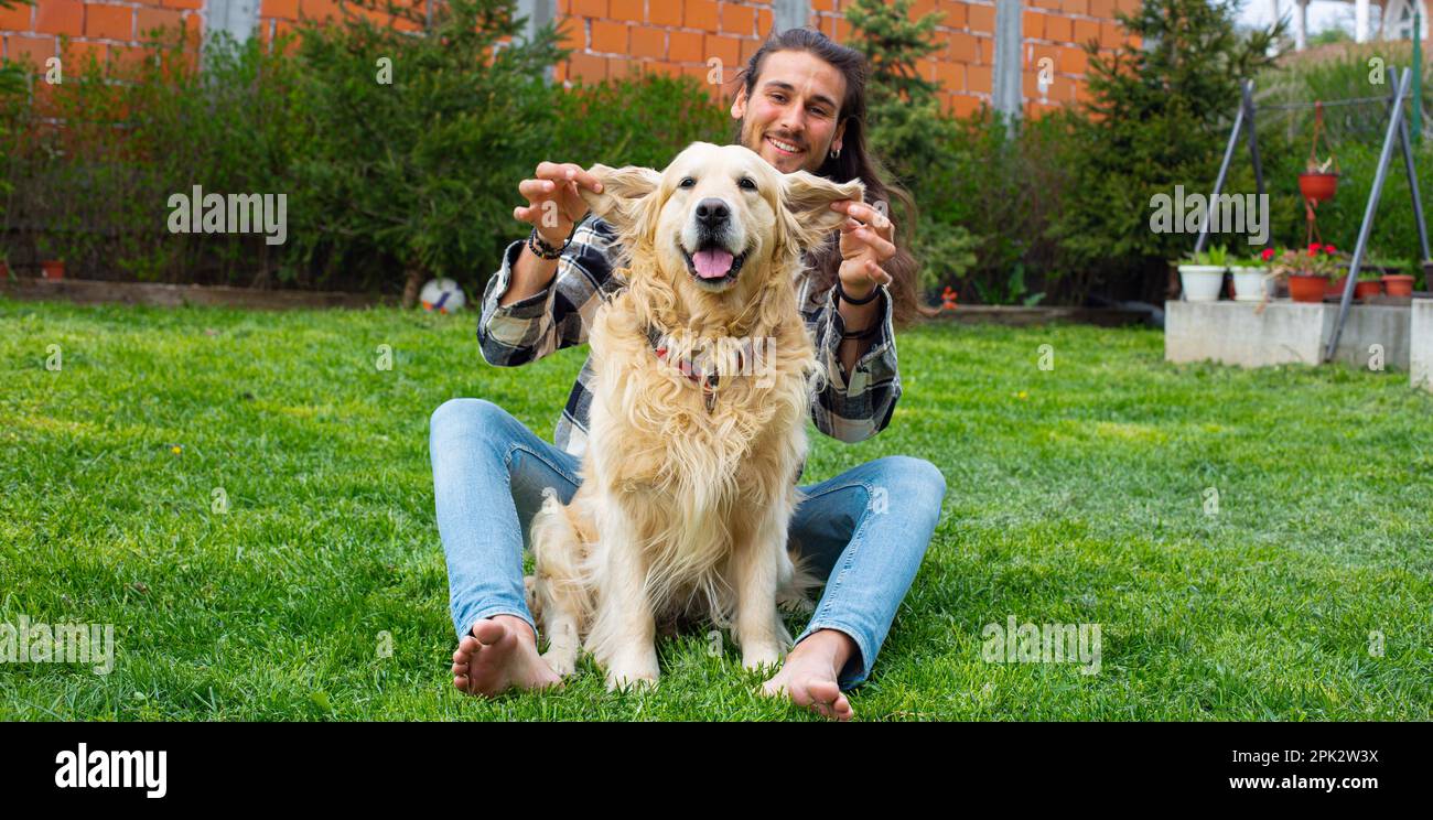 Positive man playing golden retriever hi-res stock photography and ...