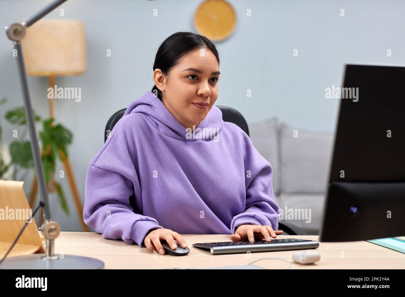 Portrait of young woman wearing comfy hoodie while working at home ...