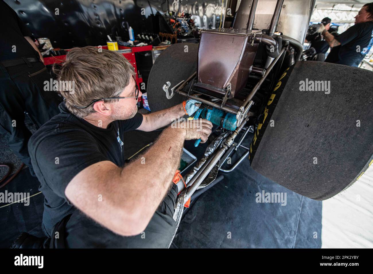 A crew member from team Mac Attack, adjust the parachute on the Drag ...