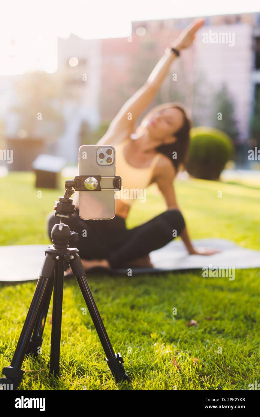 Smartphone on tripod in front of woman, healthy sports woman recording ...