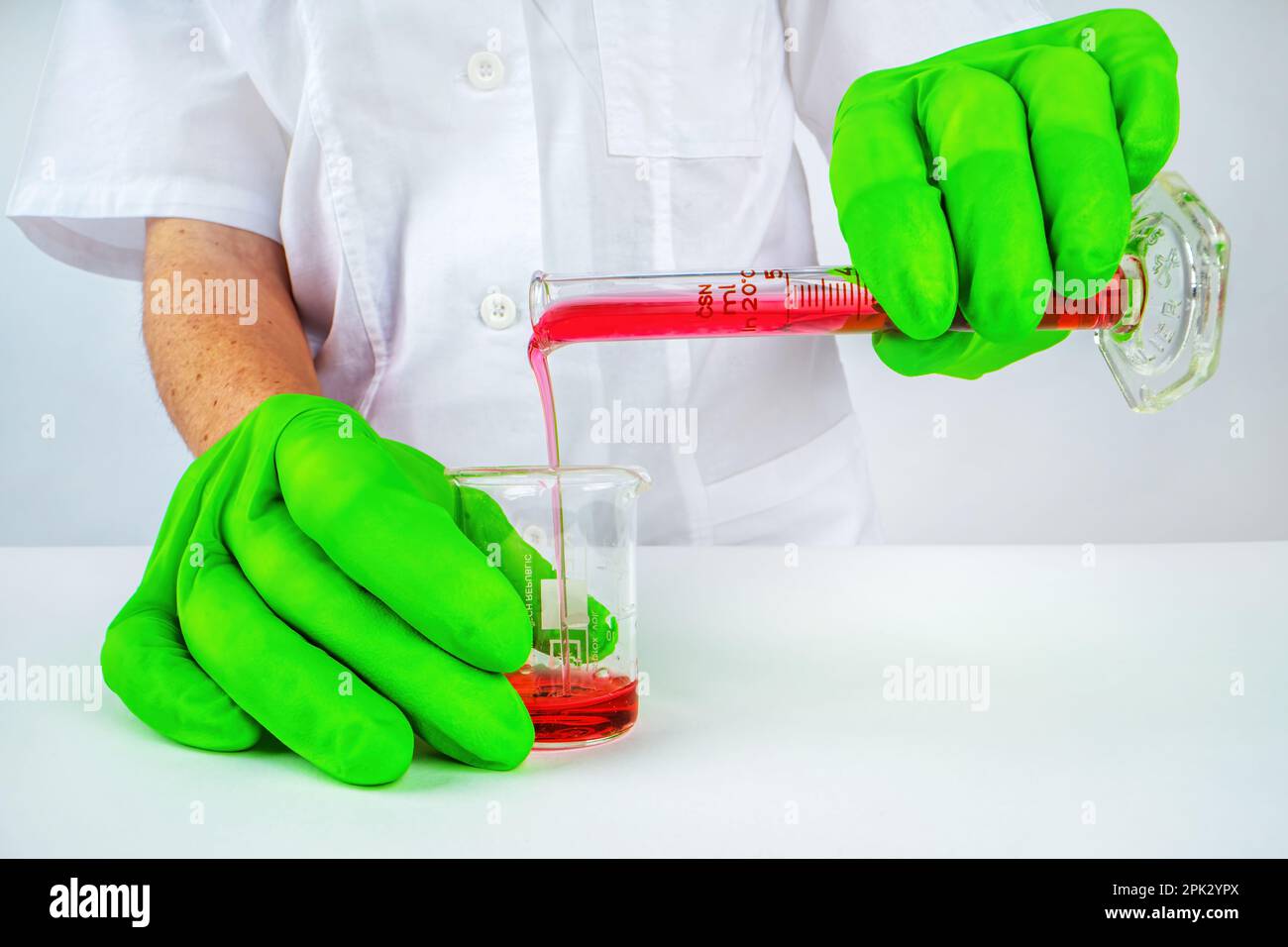 A scientist doctor pouring red fluid (blood) from a test tube into a ...