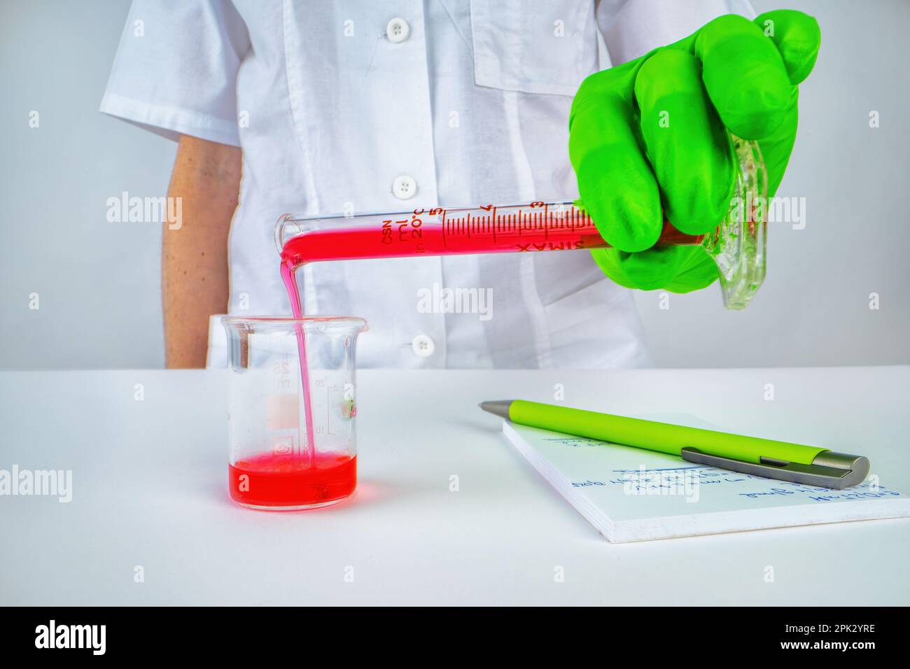 A scientist doctor pouring red fluid (blood) from a test tube into a ...