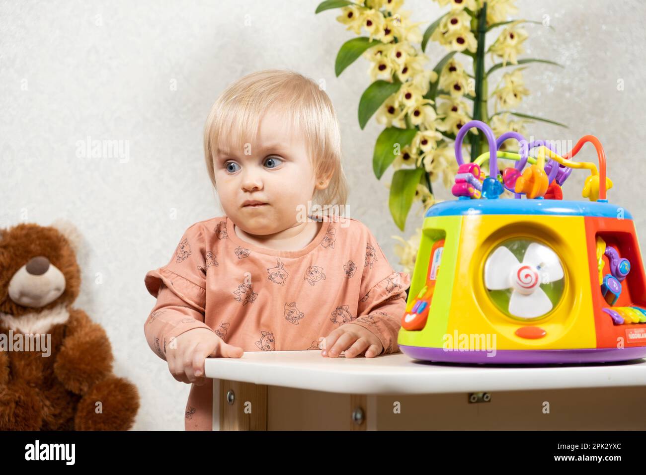 A one-and-a-half-year-old girl plays with a musical glowing toy ...
