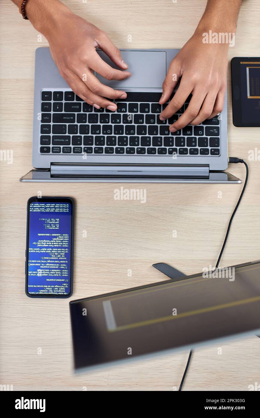 Vertical top view of male hands typing and writing code for mobile ...