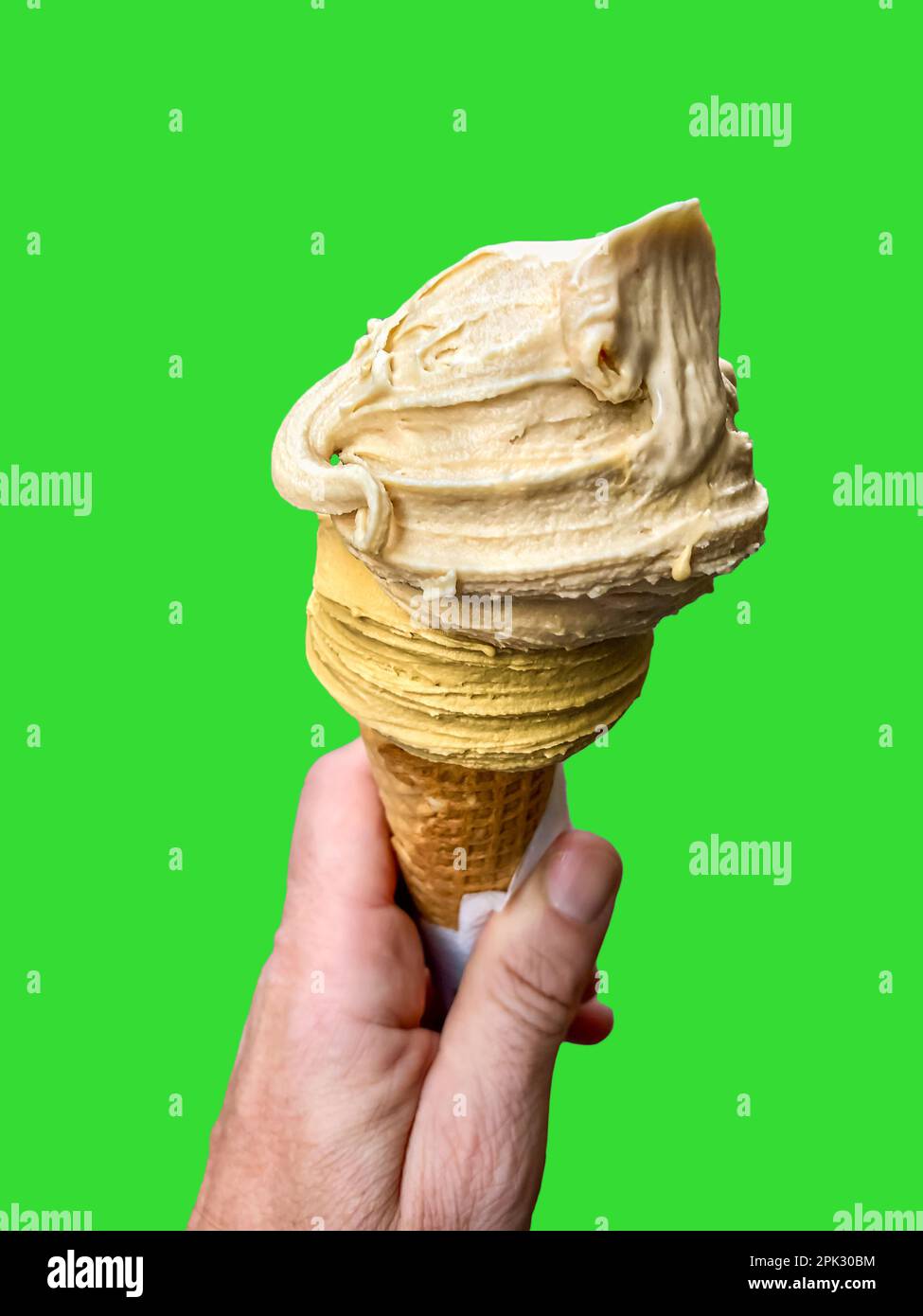 Ice cream in cone in hand isolated on greenscreen background for ...
